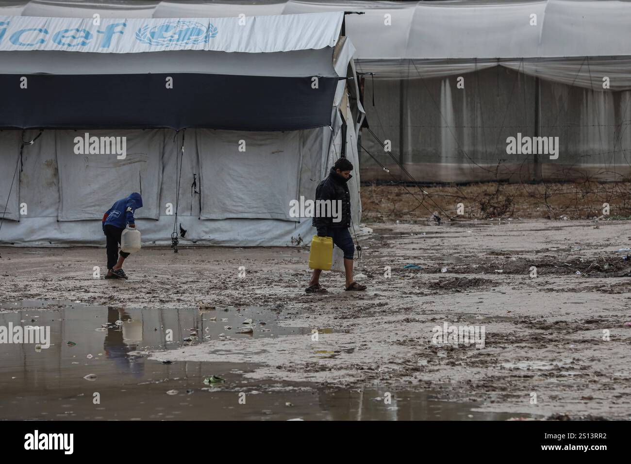 Palestinians, including children, line up to collect drinking water ...