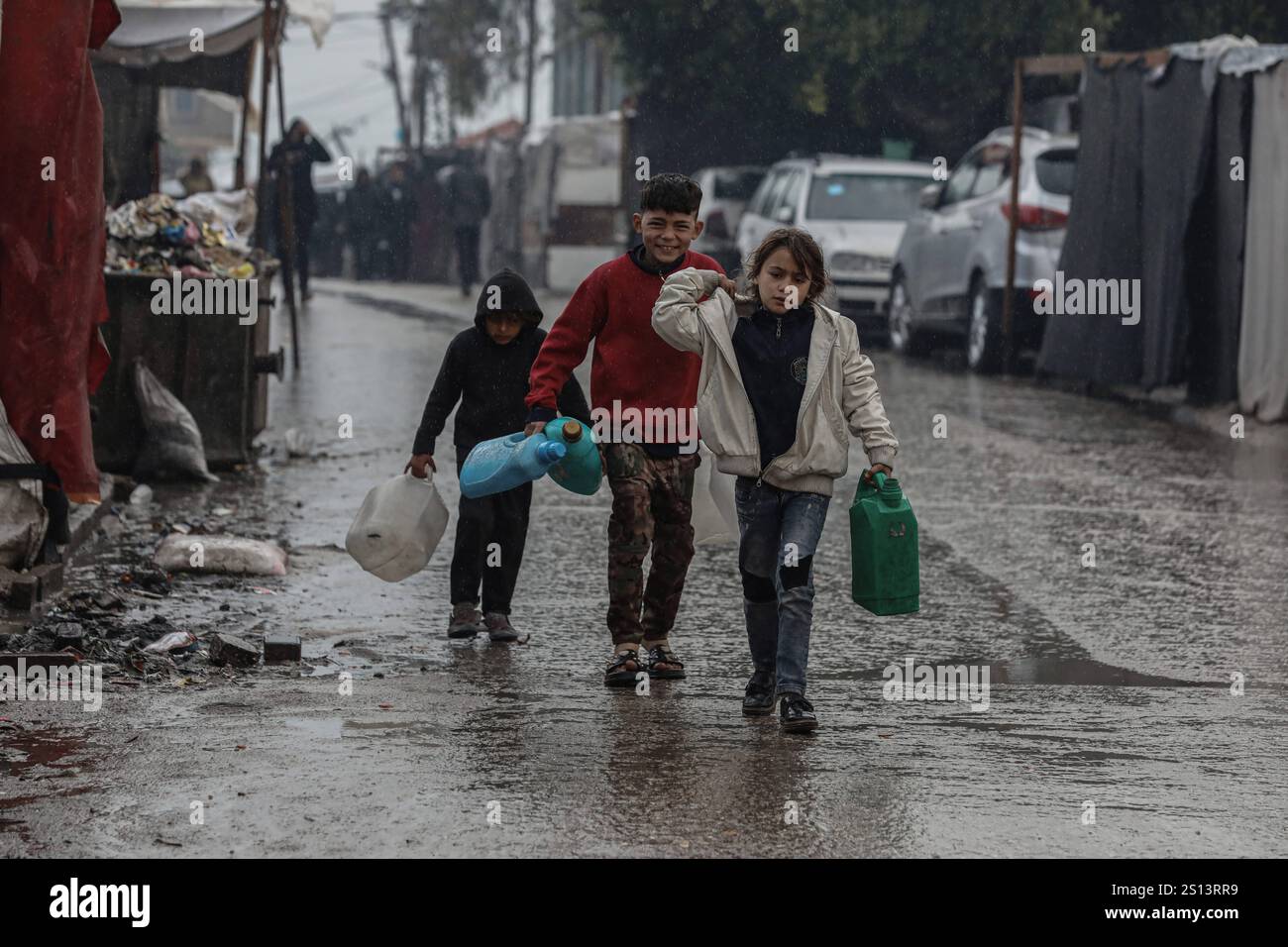 Palestinians, including children, line up to collect drinking water ...