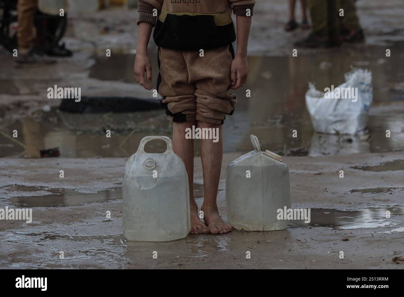 Palestinians, including children, line up to collect drinking water ...