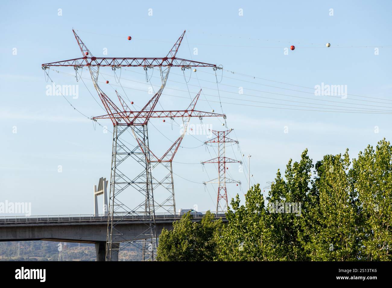 Electricity pylons and power lines dominate the skyline, crossing a ...