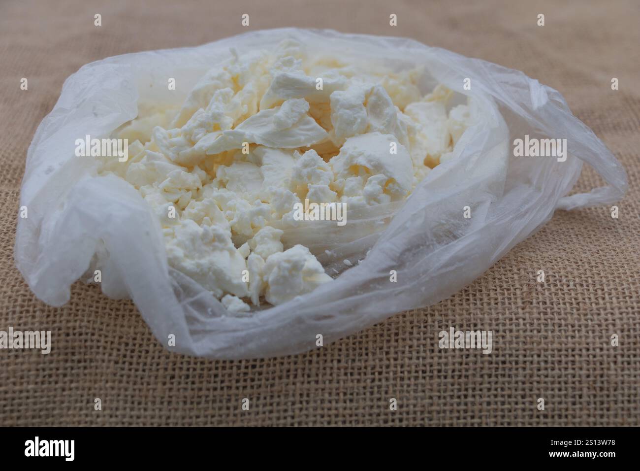 A plastic bag of soft white cheese on a burlap background Stock Photo ...