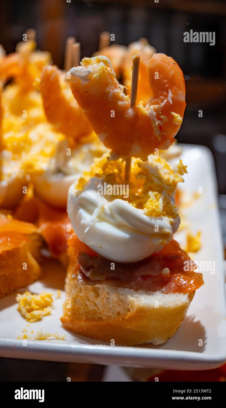 Typical snack of Basque Country, pinchos or pinxtos skewers with small ...