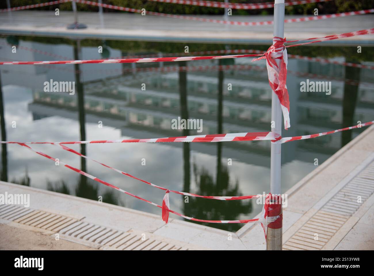 Red and white caution tape wrapped around poles, blocking access to a ...