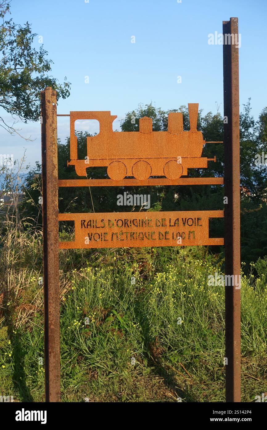 rusty iron plate in the shape of a locomotive between two railway ...