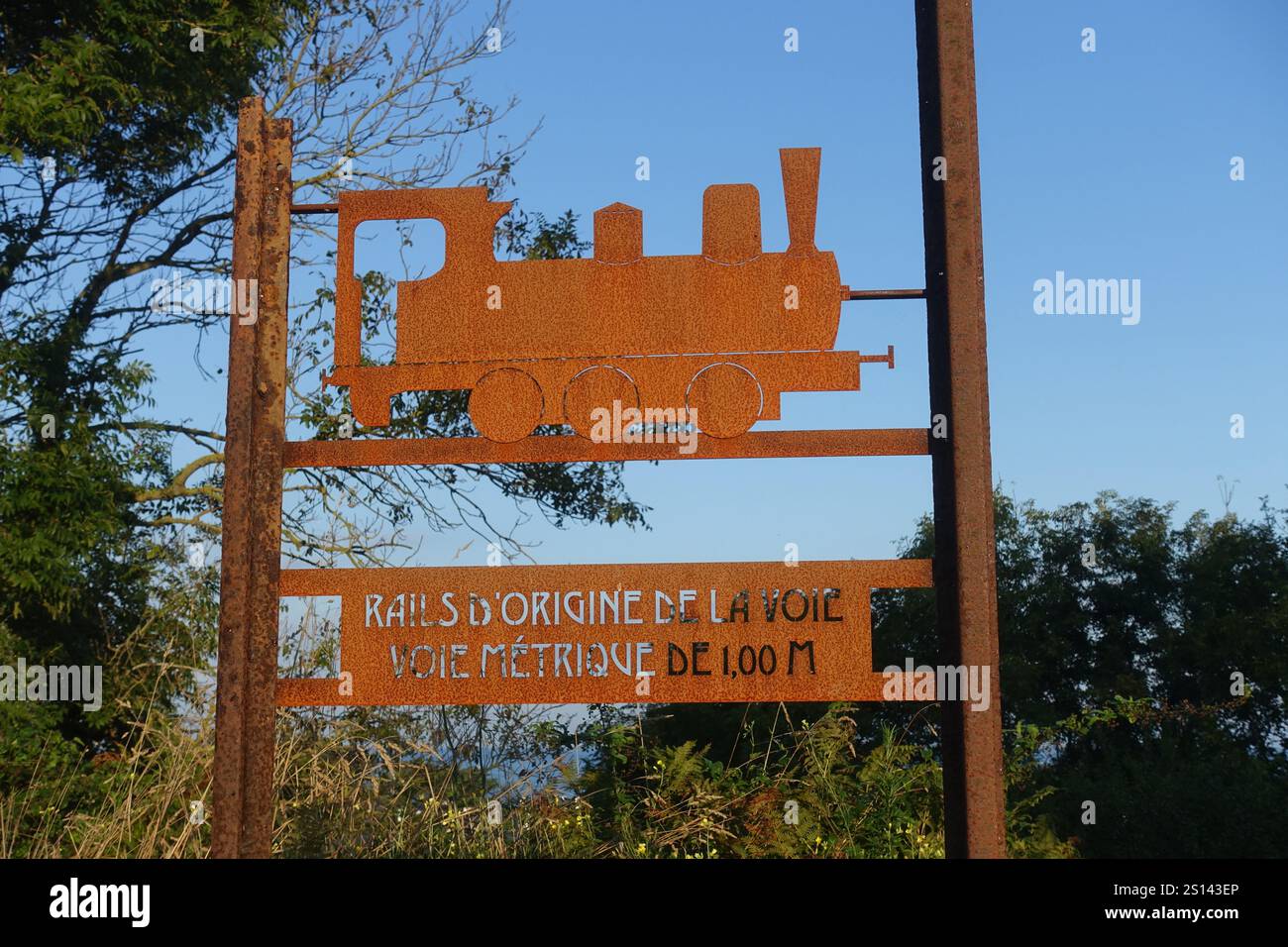 rusty iron plate in the shape of a locomotive between two railway ...