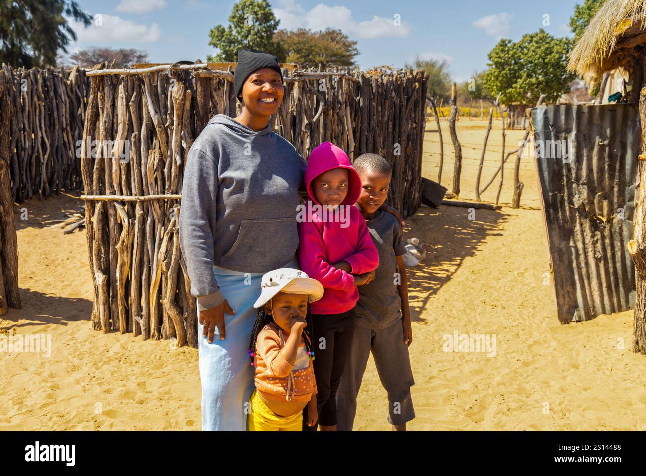 african village, family mother and kids standing in the yard , outdoors ...
