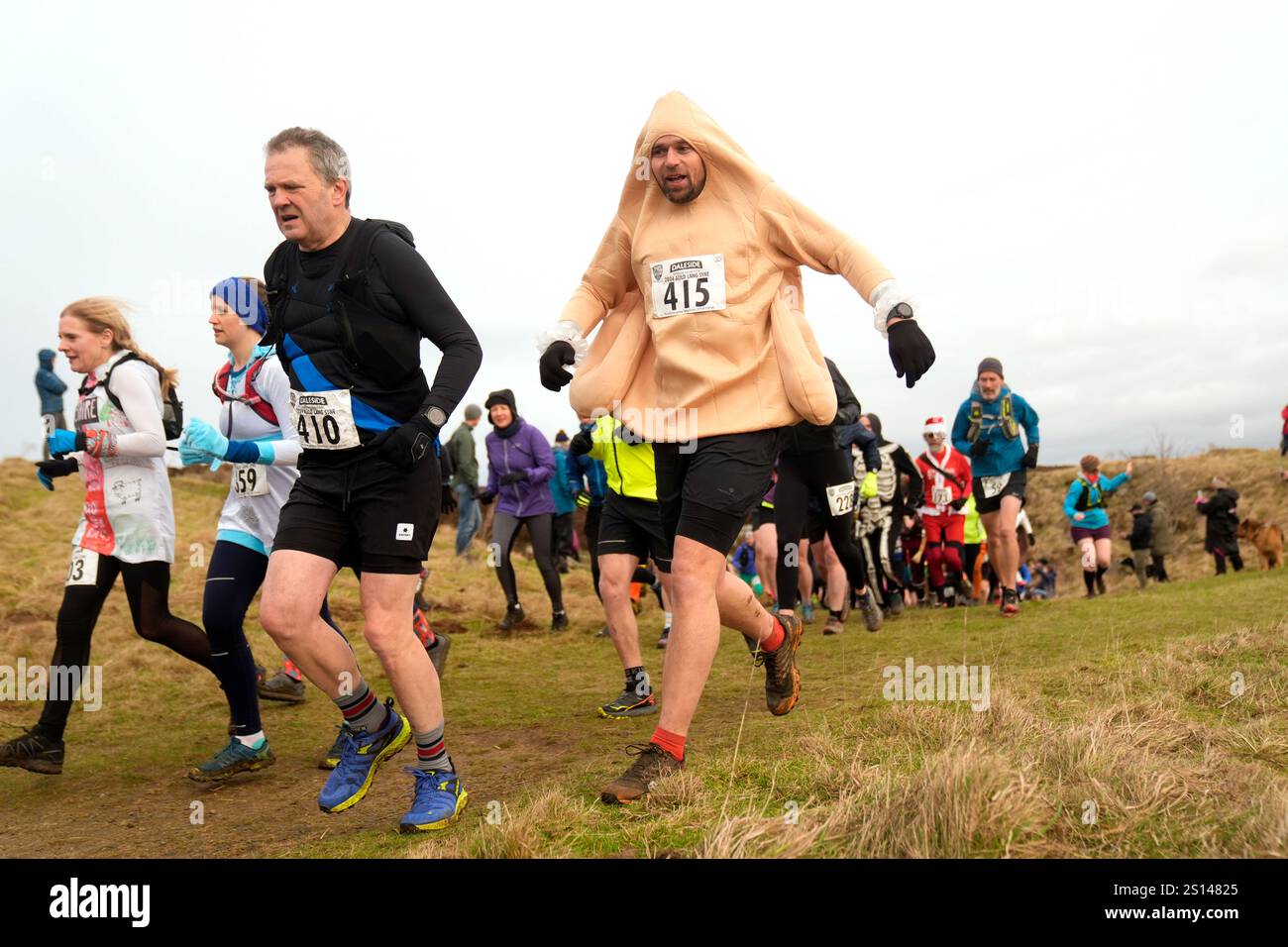 Competitors in fancy dress run across the Pennine tops near Haworth ...