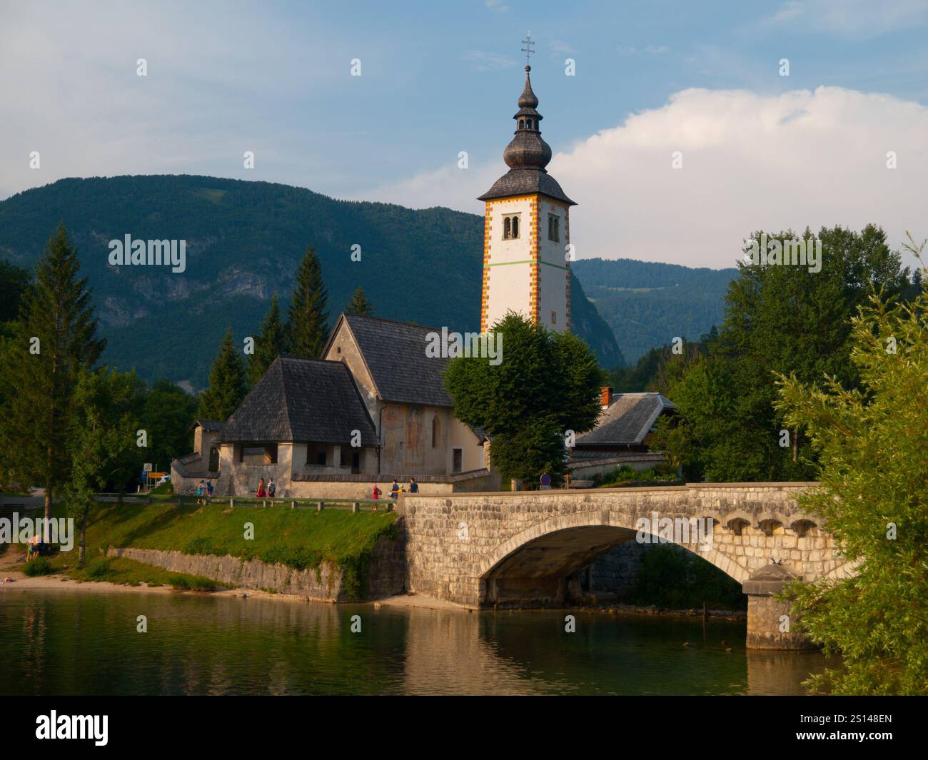 Church tower and stone bridge at Lake Bohinj in alpine village Ribicev ...