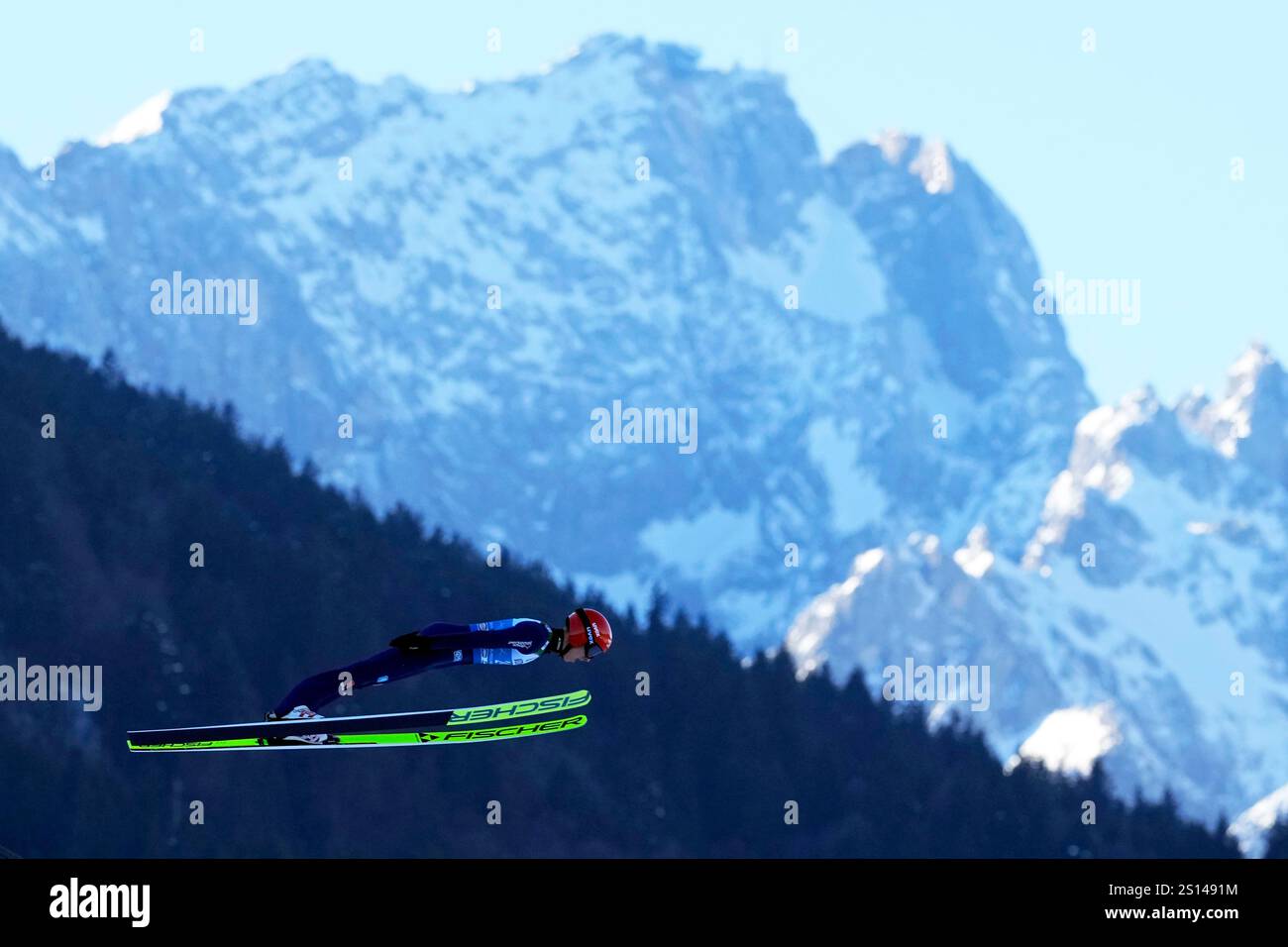 Adrian Tittel, of Germany, soars through the air, with the Zugspitze ...