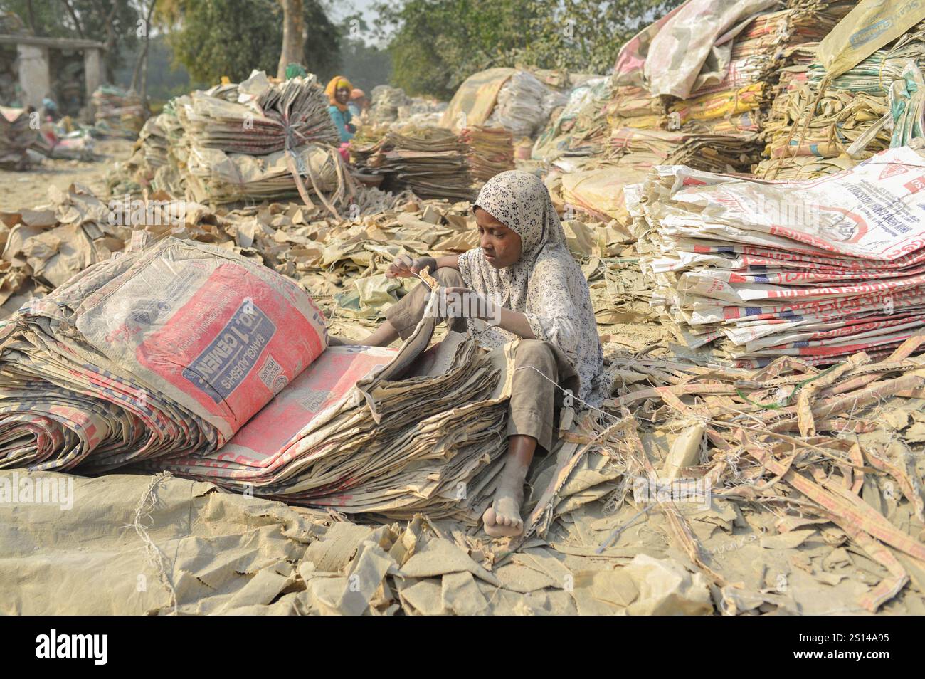 A child worker is risking their life unloading dusty cement bags beside ...