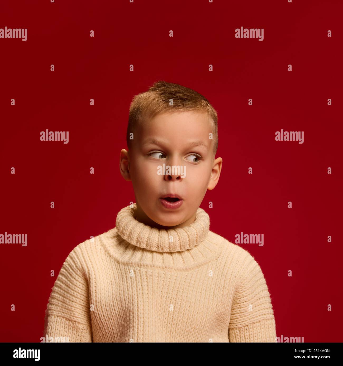Boy in beige sweater, raising eyebrows with surprised expression ...