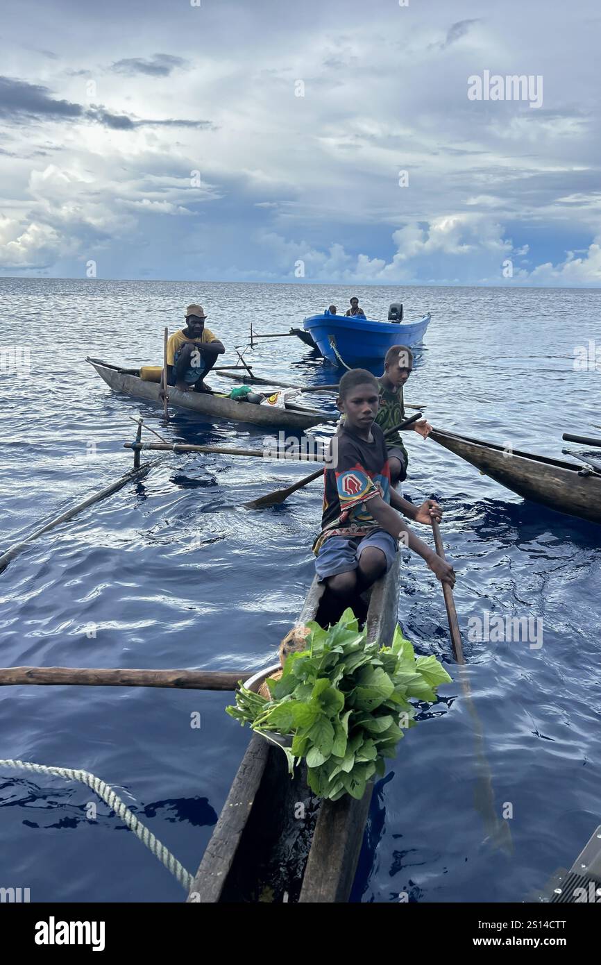 Residents of New Hanover island in their traditional dugout canoes, New ...