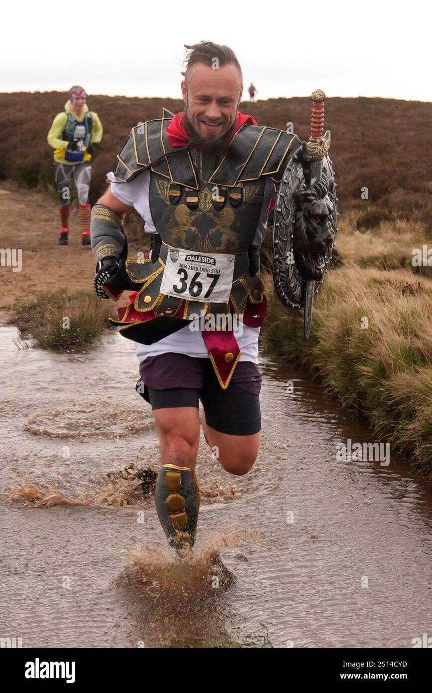 Competitors in fancy dress run across the Pennine tops near Haworth ...