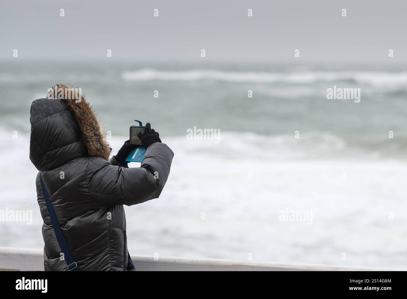 31.12.2024, Westerland --- Eine Frau fotografiert mit ihrem Smartphone ...
