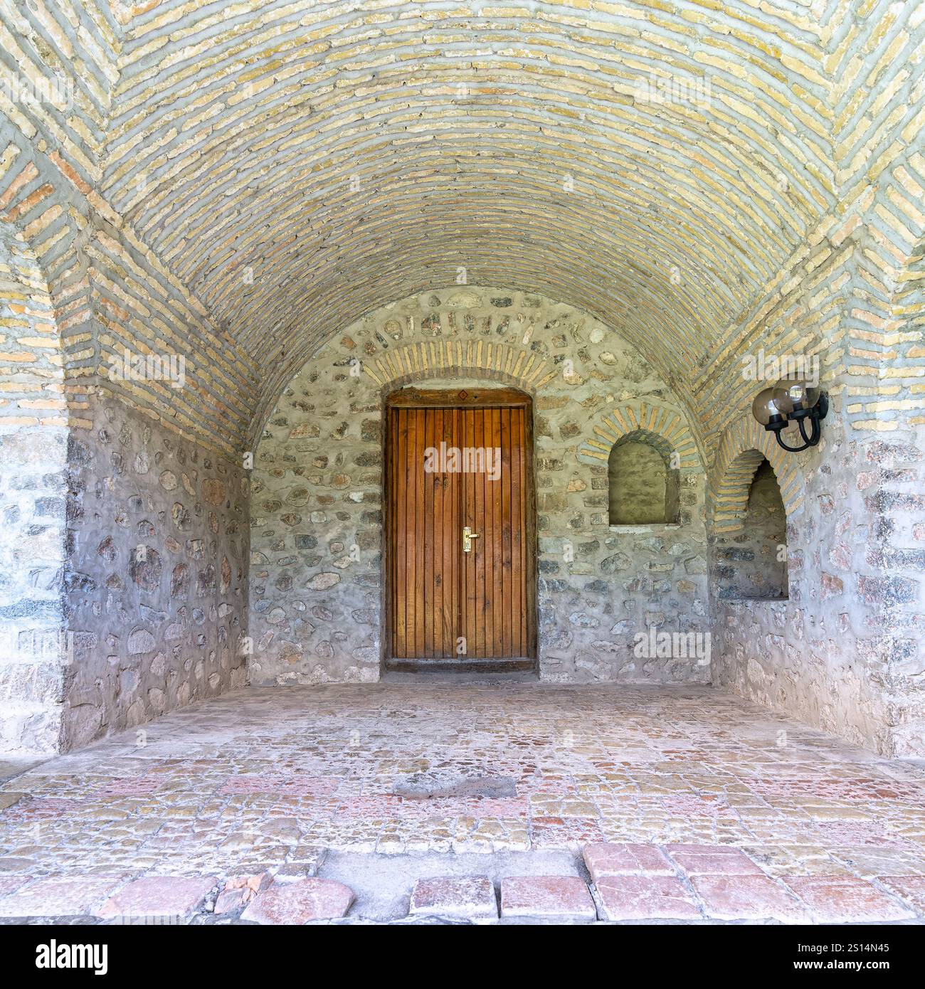 Stone archway with a rustic wooden door, vaulted brick ceiling ...