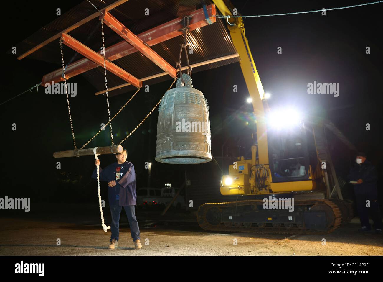 A person rings the New Year's Eve Bell, hung by heavy machinery at ...