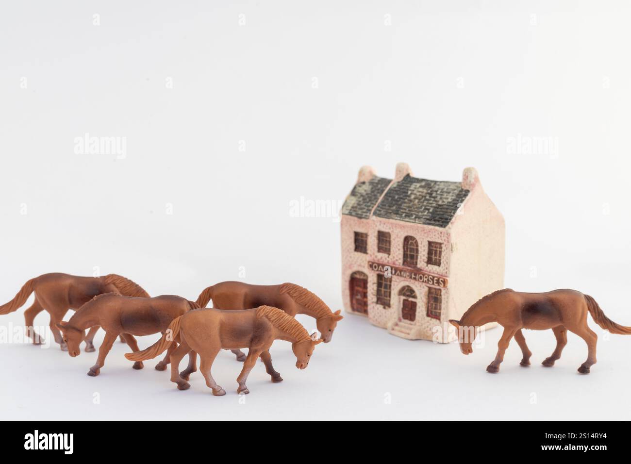 Miniature plastic toy horses with a stable on white isolated background ...