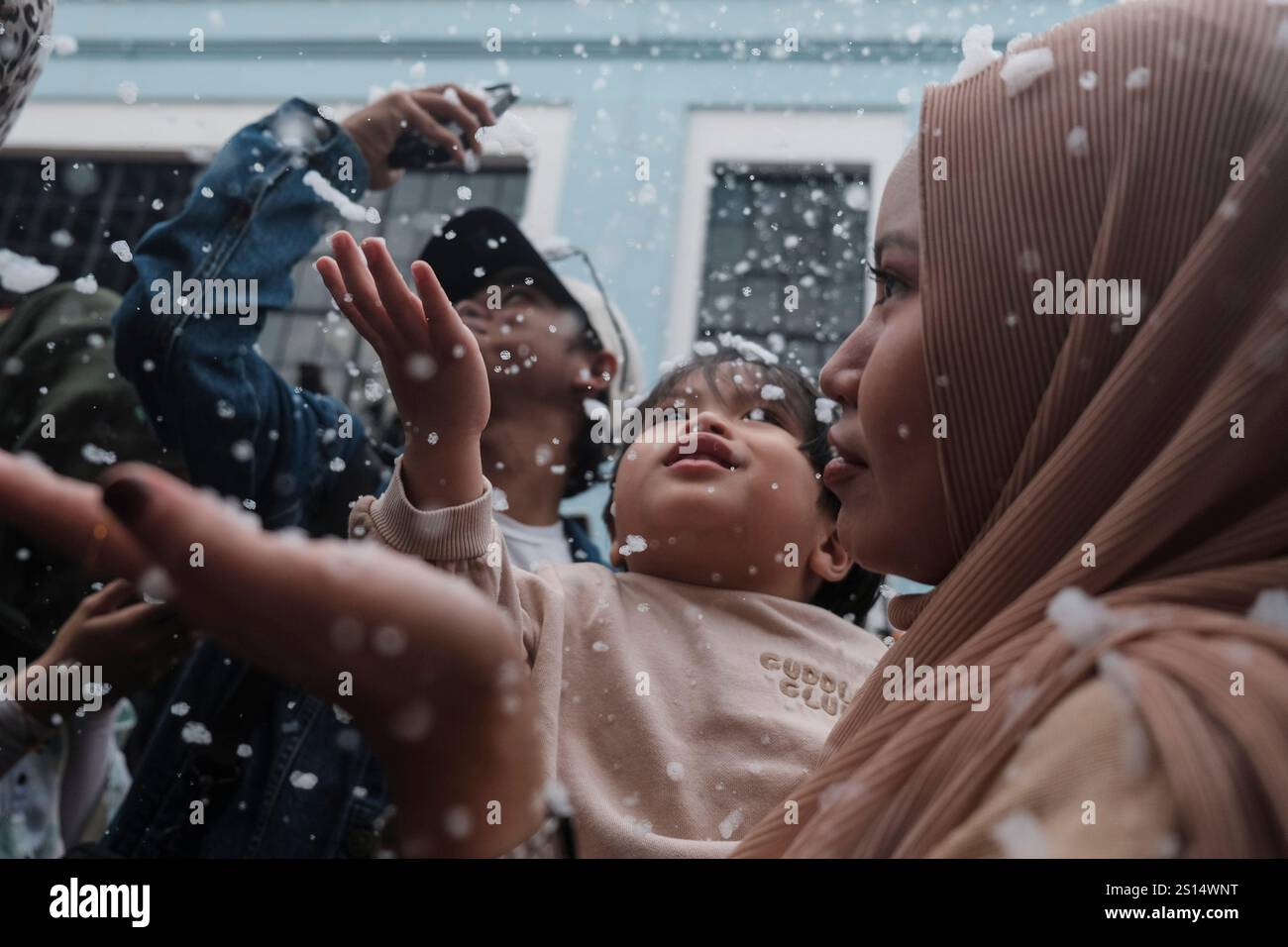A family is seen with artificial snow during the last weekend of 2024 ...