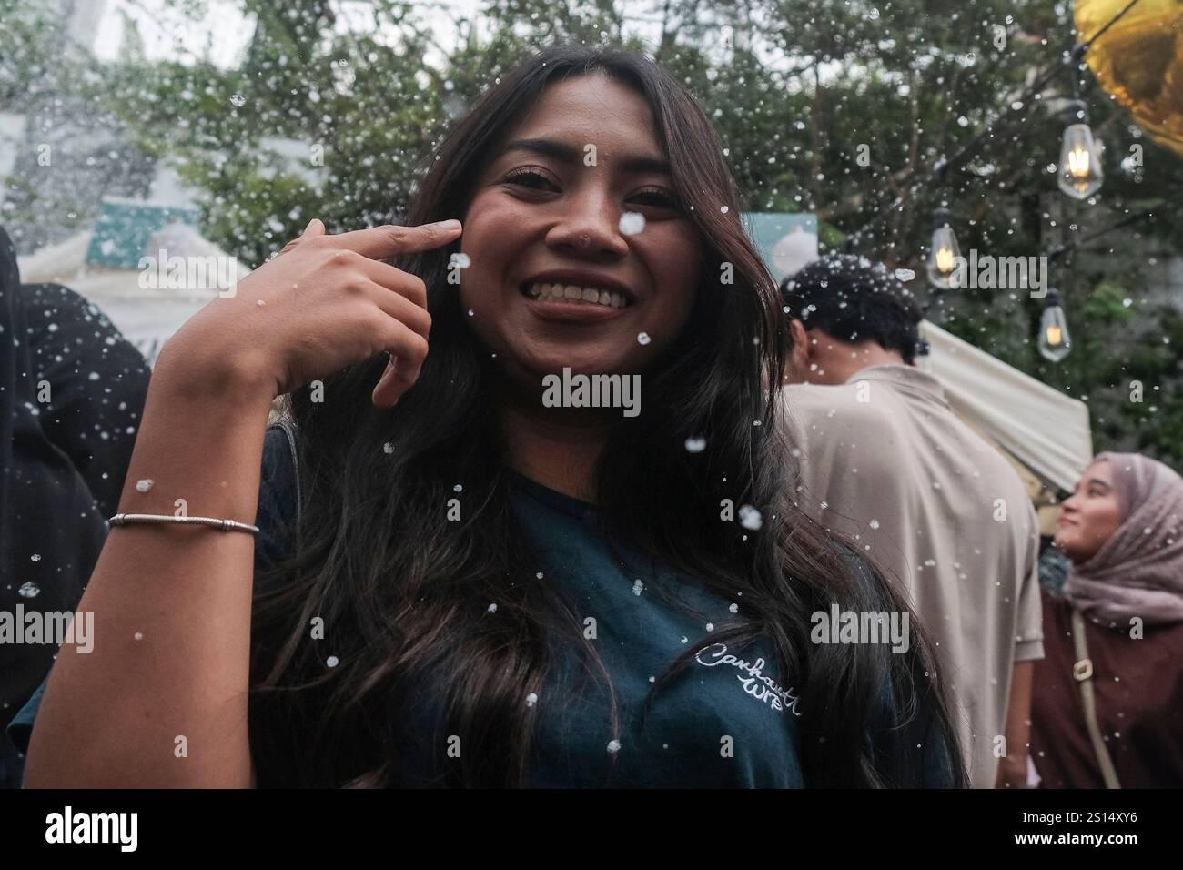 A lady plays with artificial snow during the last weekend of 2024 at ...