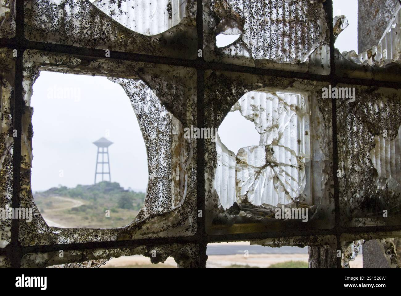 Broken windows with view of water tower at the ruins of the Bokor ...