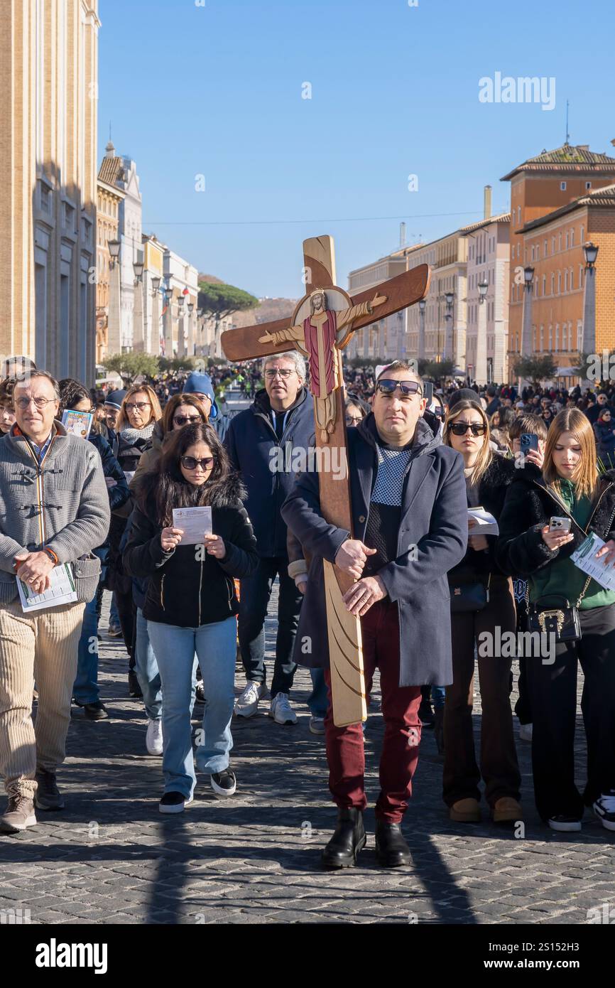 A group of Pilgrims carry a crucifix, marching in procession to St. Peter's Basilica during the ...