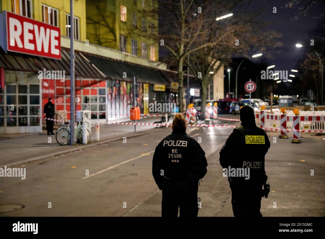 Police officers stand guard in front of a Rewe Market after a knife ...