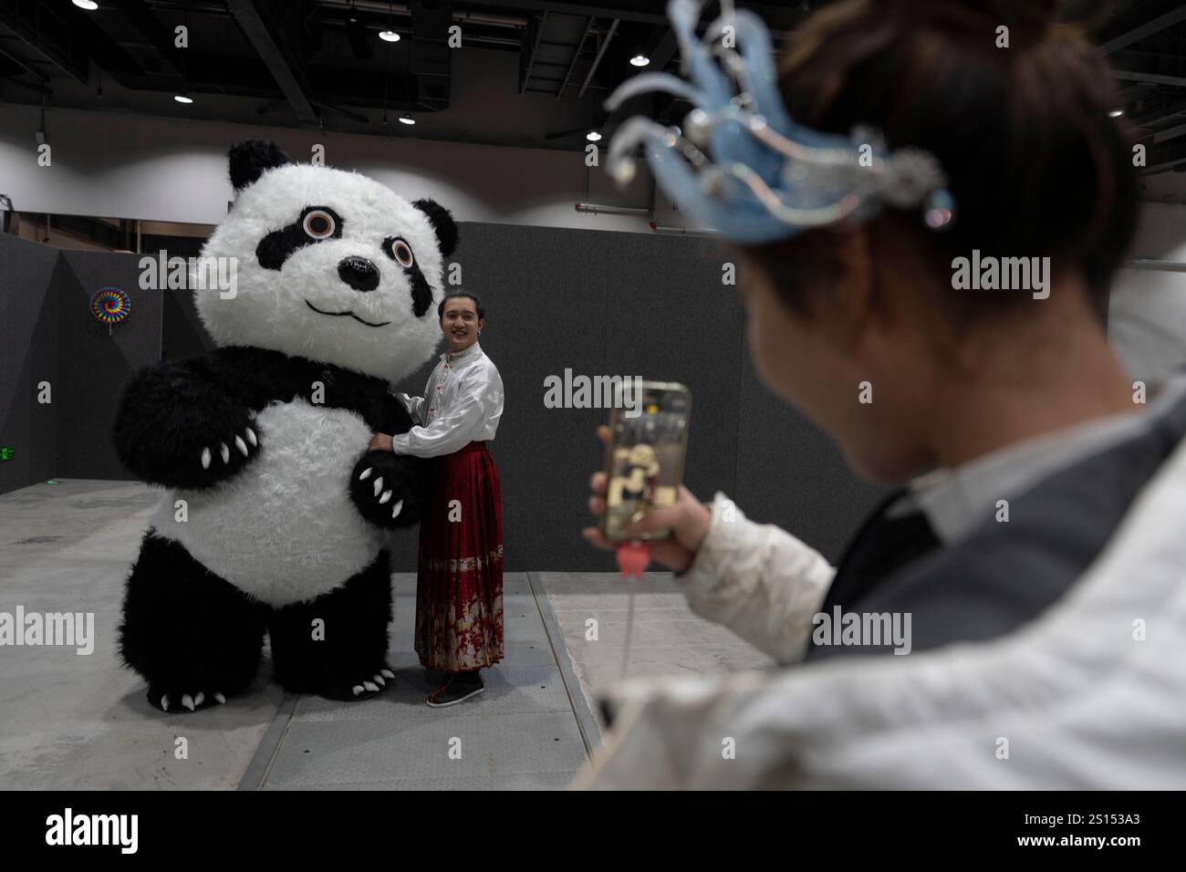 A performer poses with a Panda mascot before a count down event held in ...