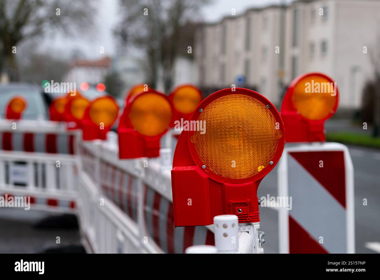 Bright orange warning lights atop construction barriers alert drivers ...