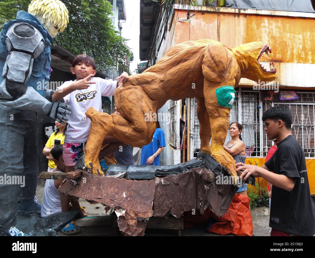 Malabon, Philippines. 31st Dec, 2024. A venom character-like effigy is paraded by young boys ...