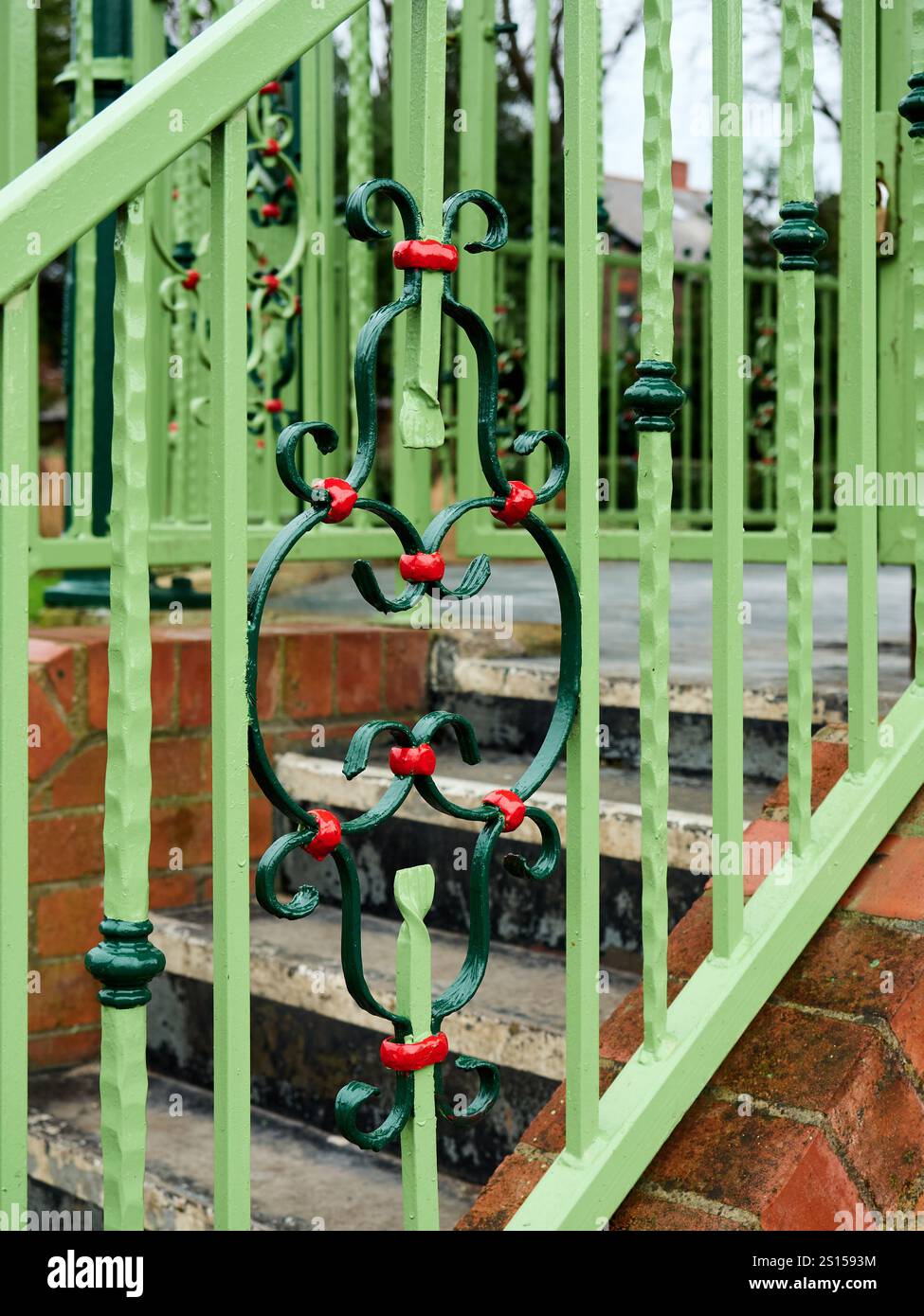 Ornate green and red wrought iron railing on brick stairs. Victoria ...