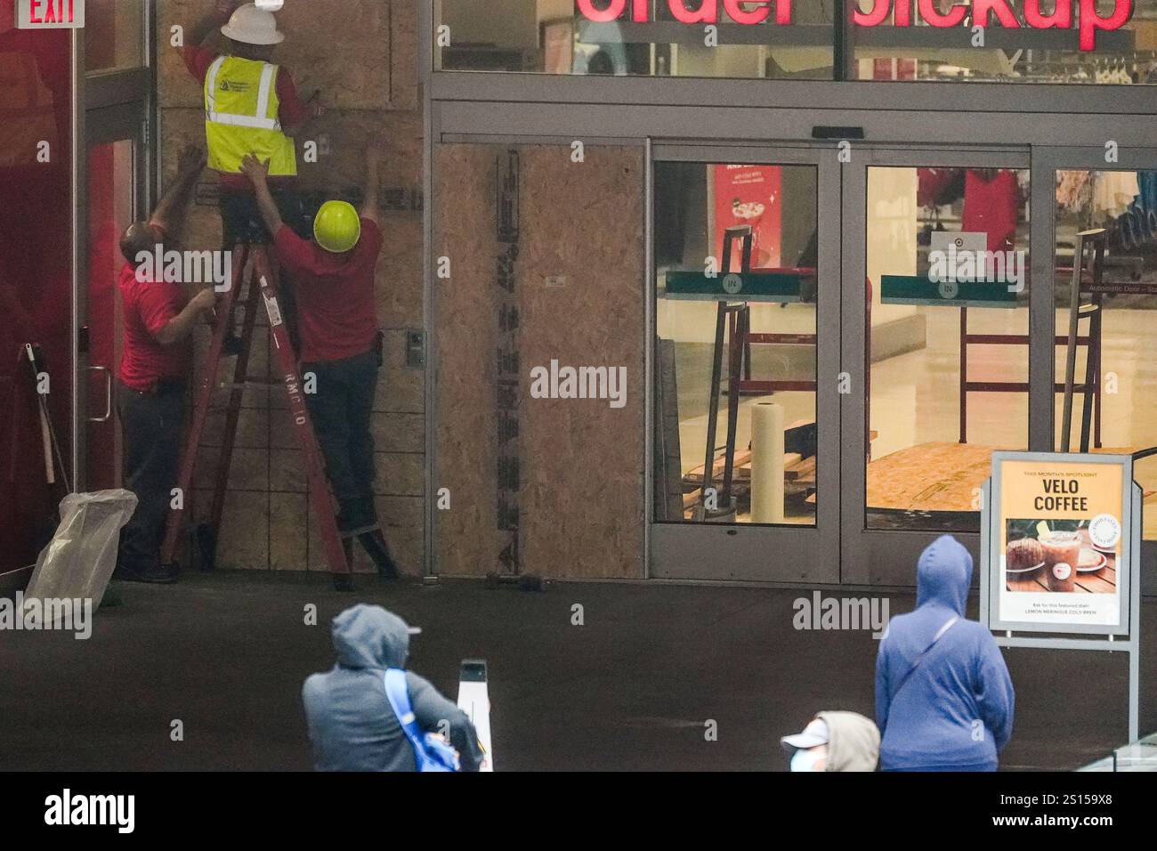 Workers secure the outside of a temporarily closed Target store after two security guards were ...