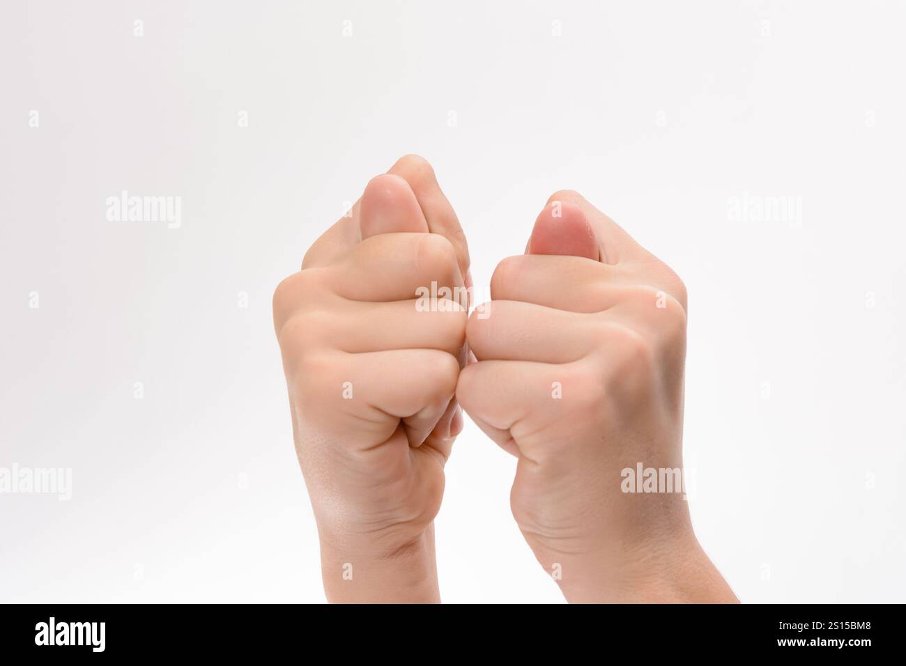 Close-up shot of two hands gently clasped together against a plain ...