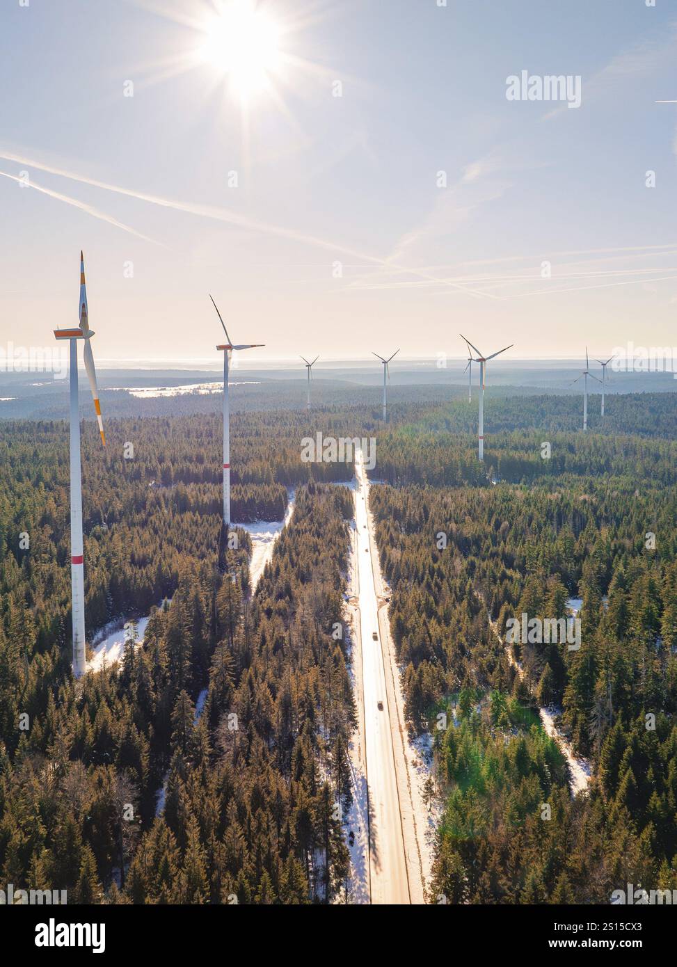 Wind turbines along a snow-covered road in a forest, Seewald, Black ...