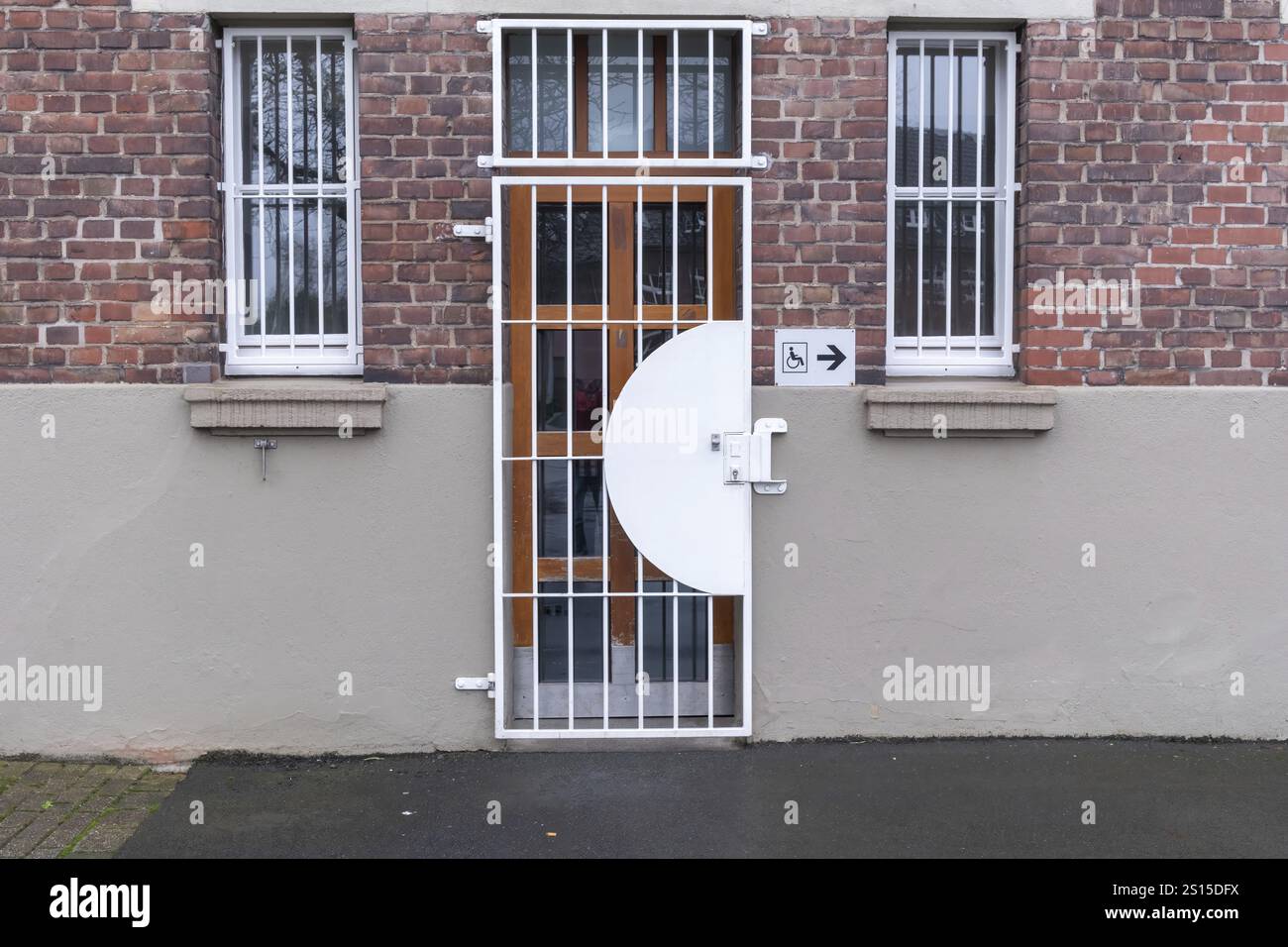 Secured entrance with half-opened white gate allowing wheelchair access ...