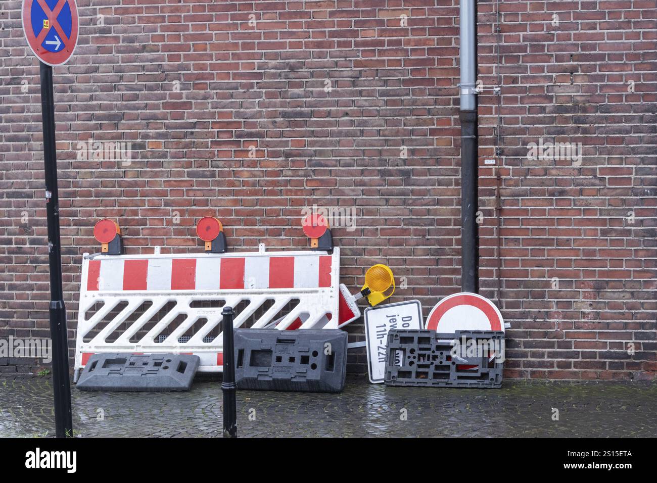 Red and white construction barrier, traffic signs, and bases stacked ...
