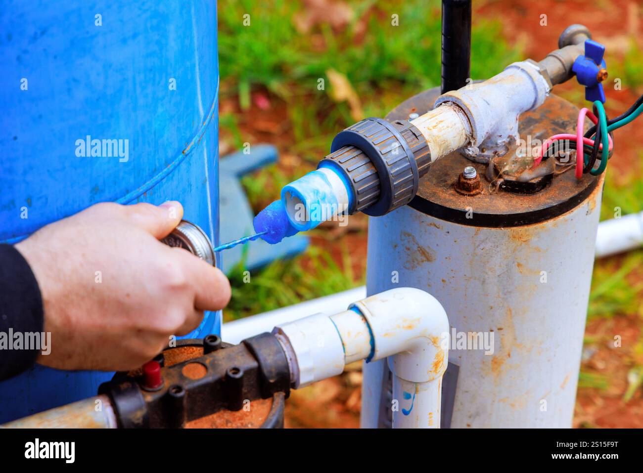 Worker connects PVC pipes water well system, ensuring clean water ...
