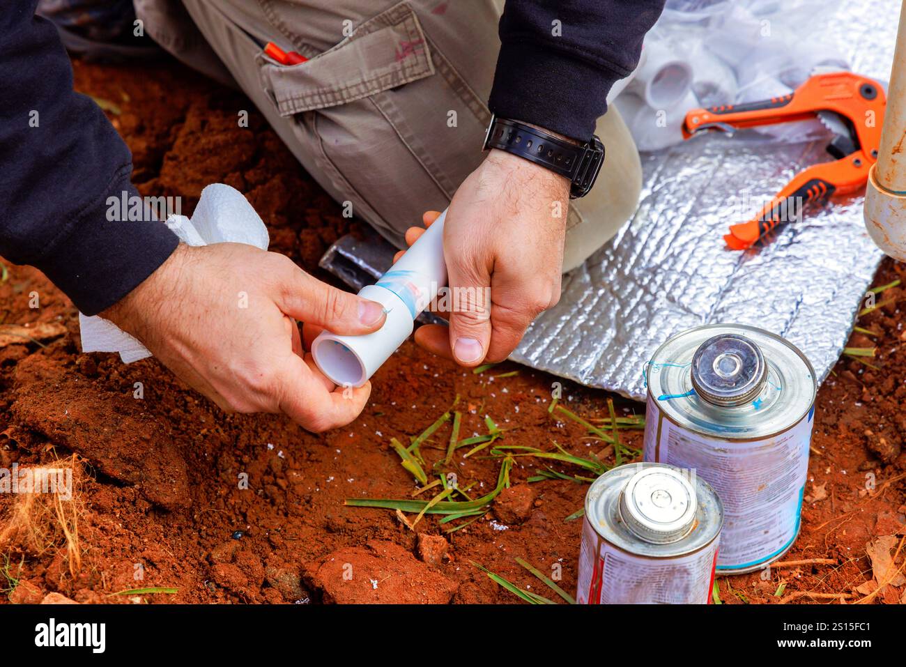 Worker connects on securely attaching PVC piping while working on pipes ...