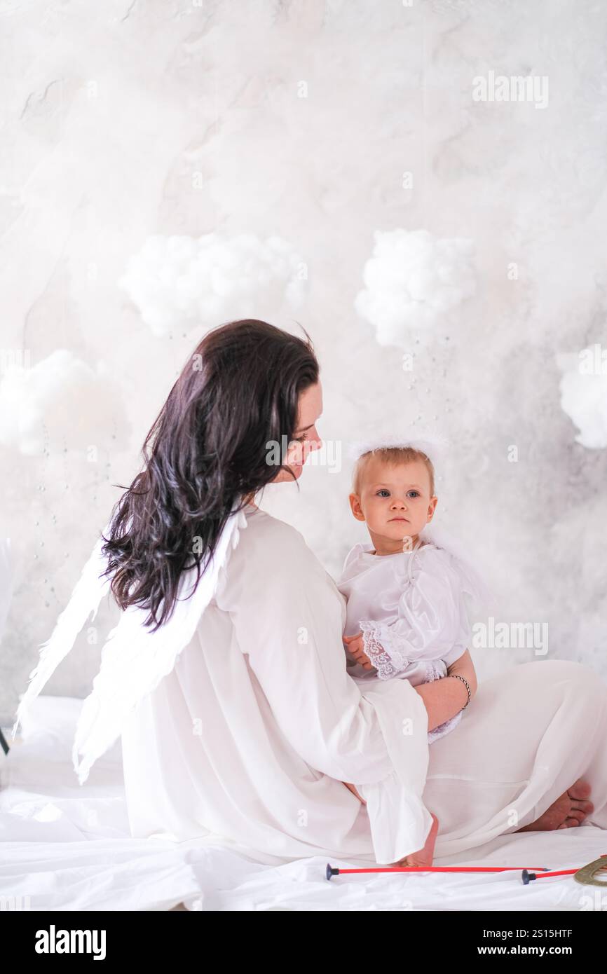 Beautiful mother and her toddler daughter wearing angel costumes. High ...