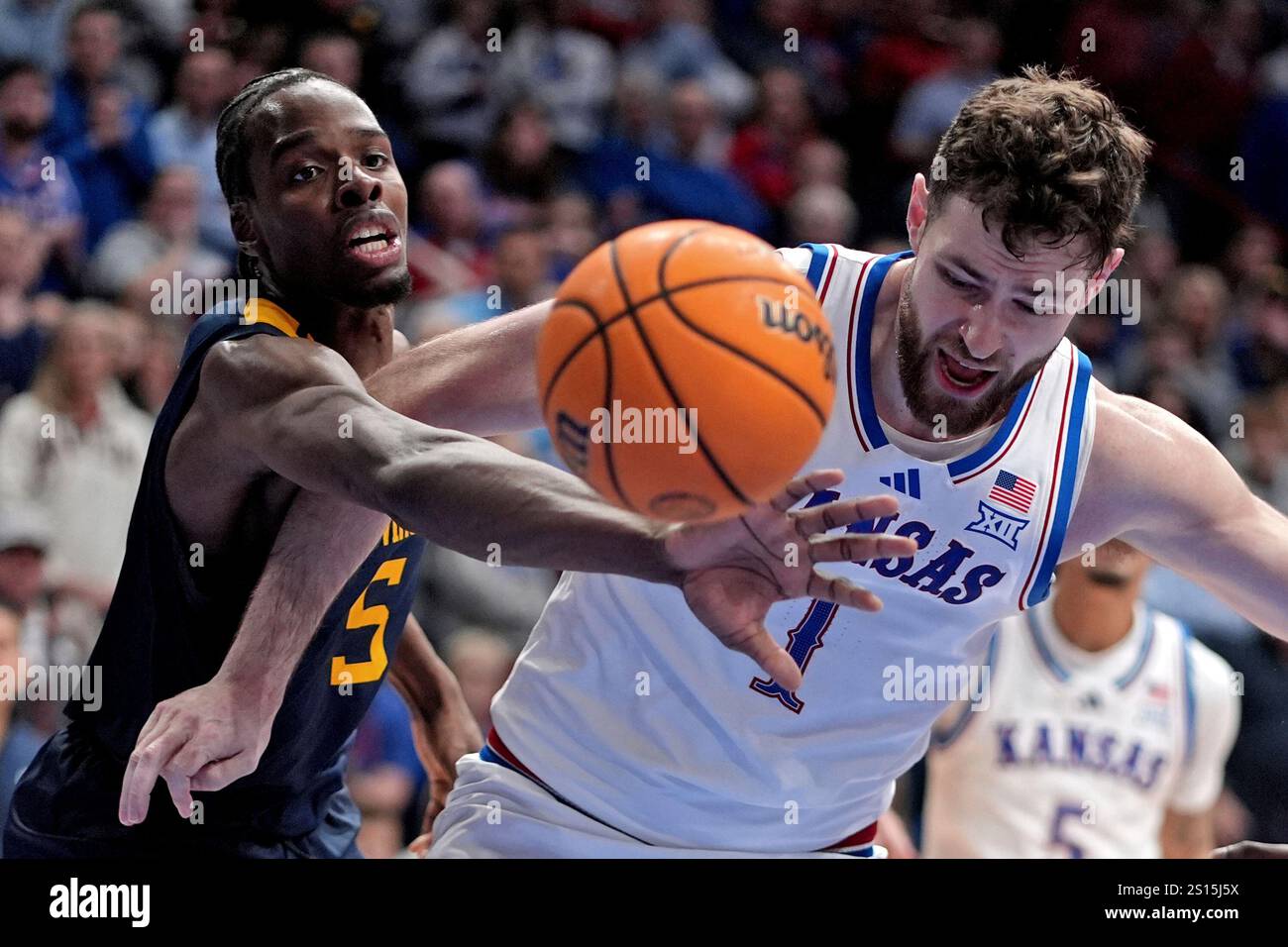 West Virginia guard Toby Okani (5) and Kansas center Hunter Dickinson ...