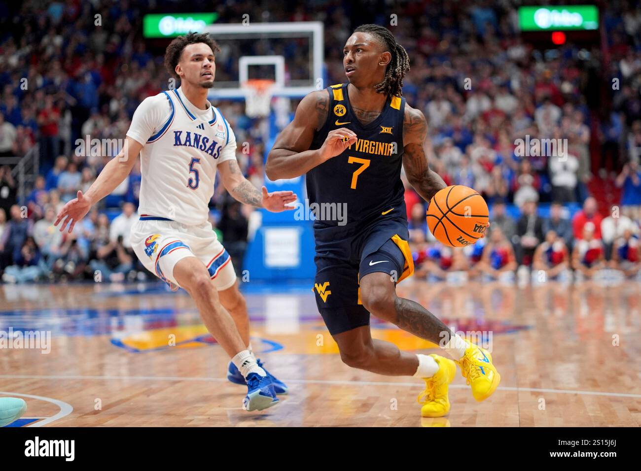 West Virginia guard Javon Small (7) drives past Kansas guard Zeke Mayo ...