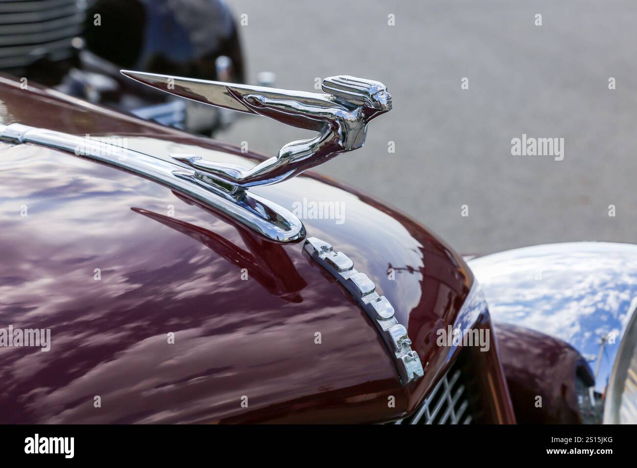 A chrome "flying lady" hood ornament on an antique maroon Auburn ...