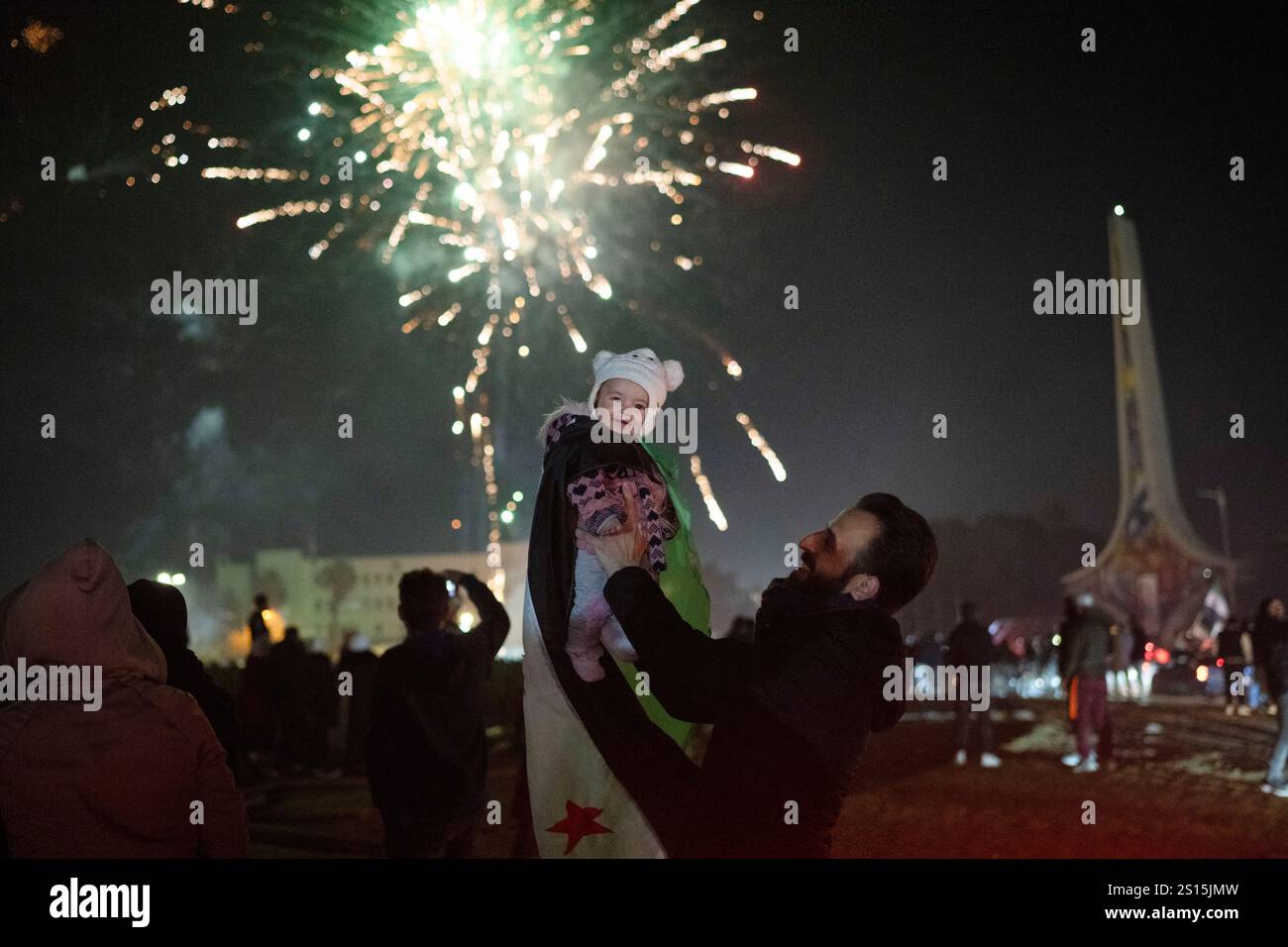 Bilal holds up his 5 month-old daughter Liin during New Year's Eve ...