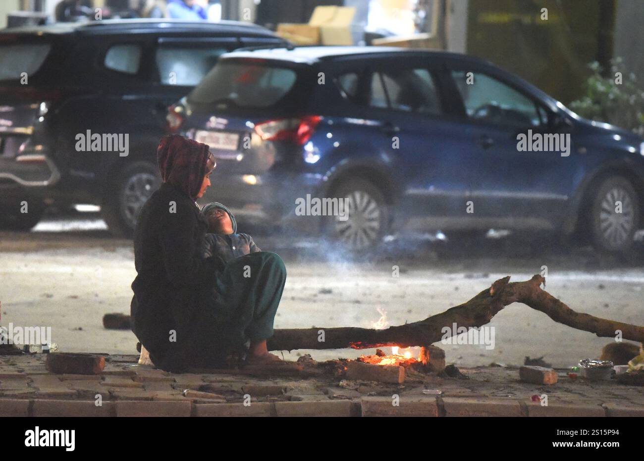 GURUGRAM, INDIA - DECEMBER 30: A homeless woman and her child warm ...