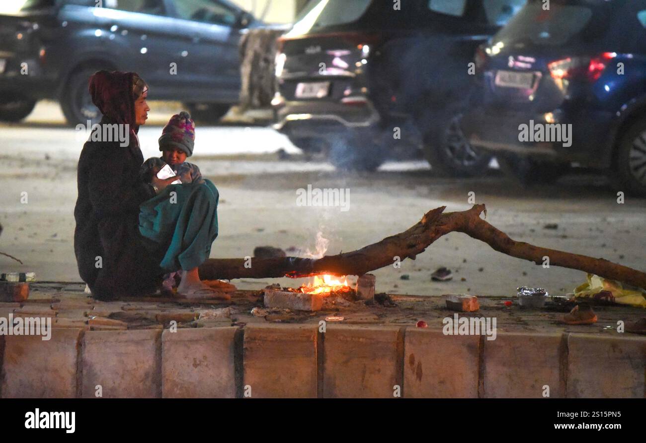 GURUGRAM, INDIA - DECEMBER 30: A homeless woman and her child warm ...