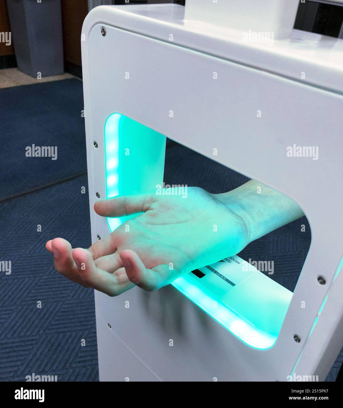 A hand is under a hand wrist temperature check inside a school building ...