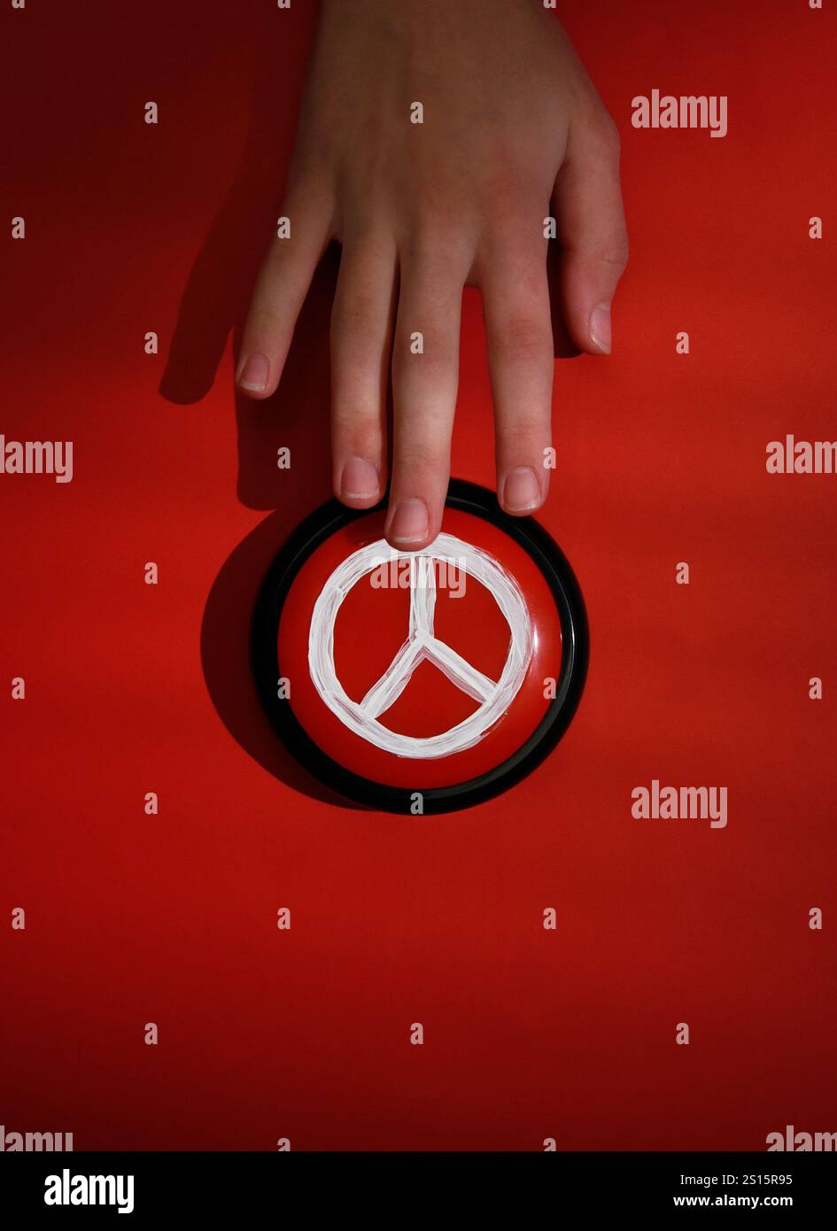 A hand is reaching on a red button with a painted peace sign for a ...