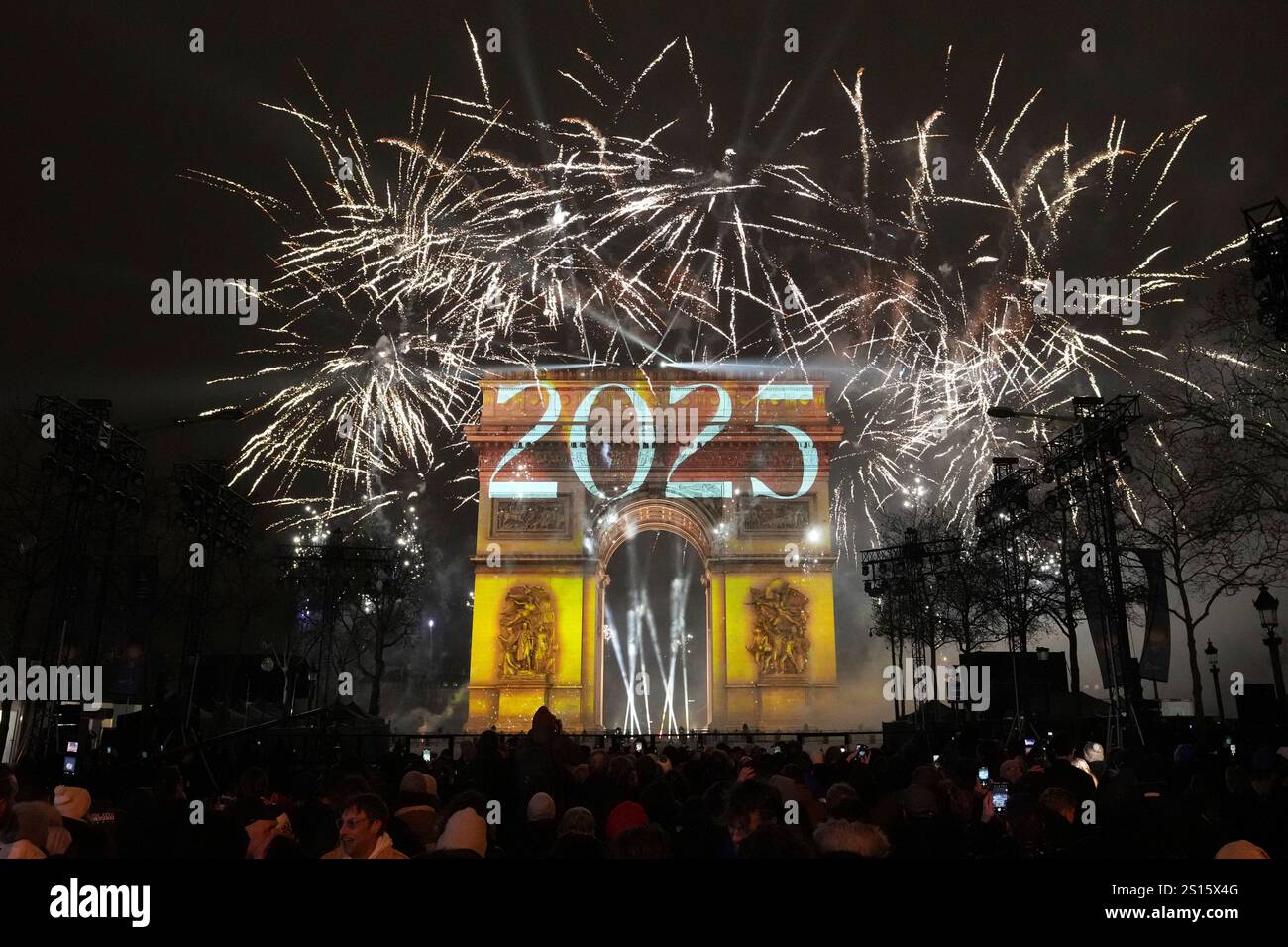 A light show is projected on the Arc de Triomphe as fireworks explode ...