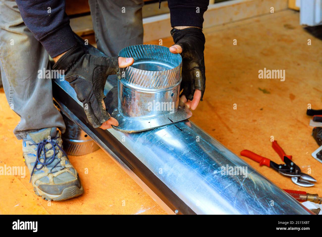 Skilled worker installs metal duct fitting, ensuring secure connection ...
