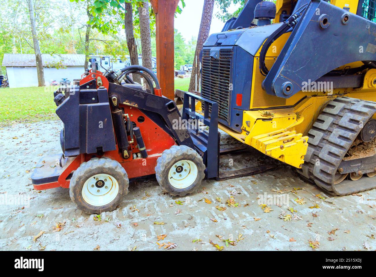 Two pieces of construction tracked loader are parked adjacent to each ...