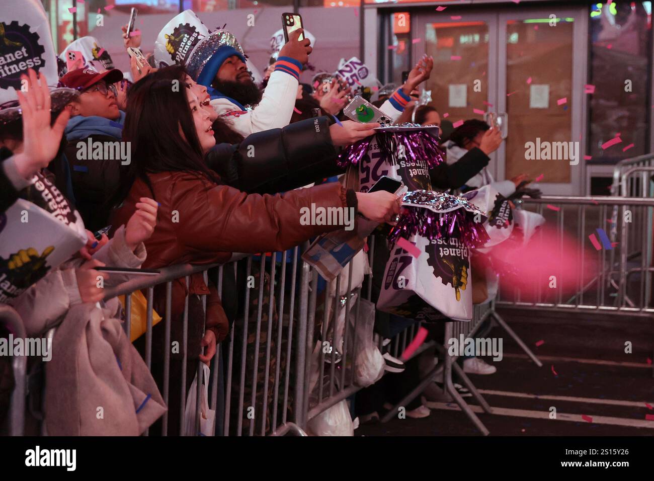 Revelers catch confetti from a performance during the annual New Year's ...